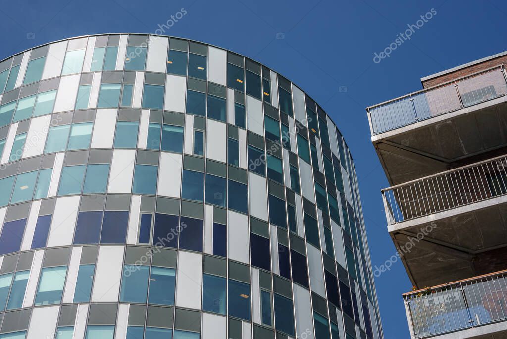 La arquitectura moderna brilla en esta imagen, con un edificio de vidrio cilíndrico al lado de ...