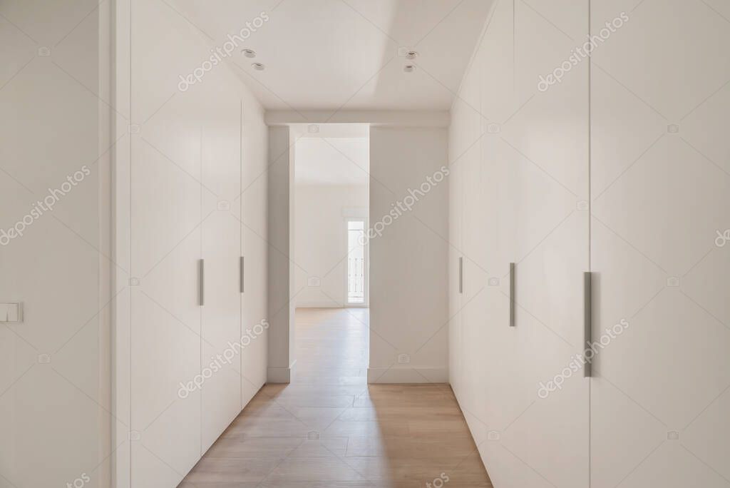 Dormitorio con un walk-in closet con puertas de madera lisas a cada ...