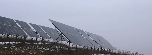 Solar panels with fog on a cloudy winter morning. The concept of ...