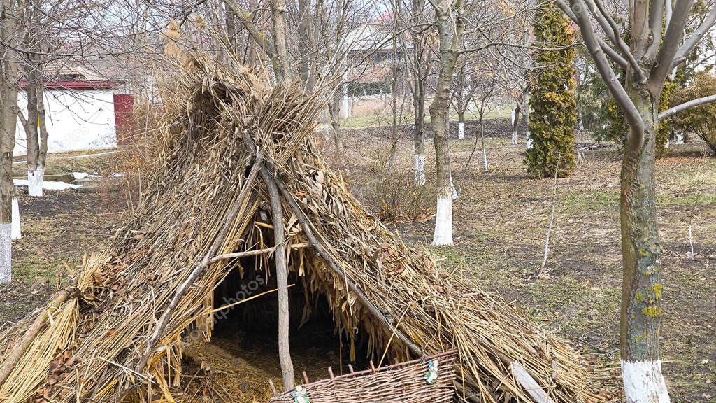 Una choza hecha de ramitas y paja en un pueblo en invierno. 2024
