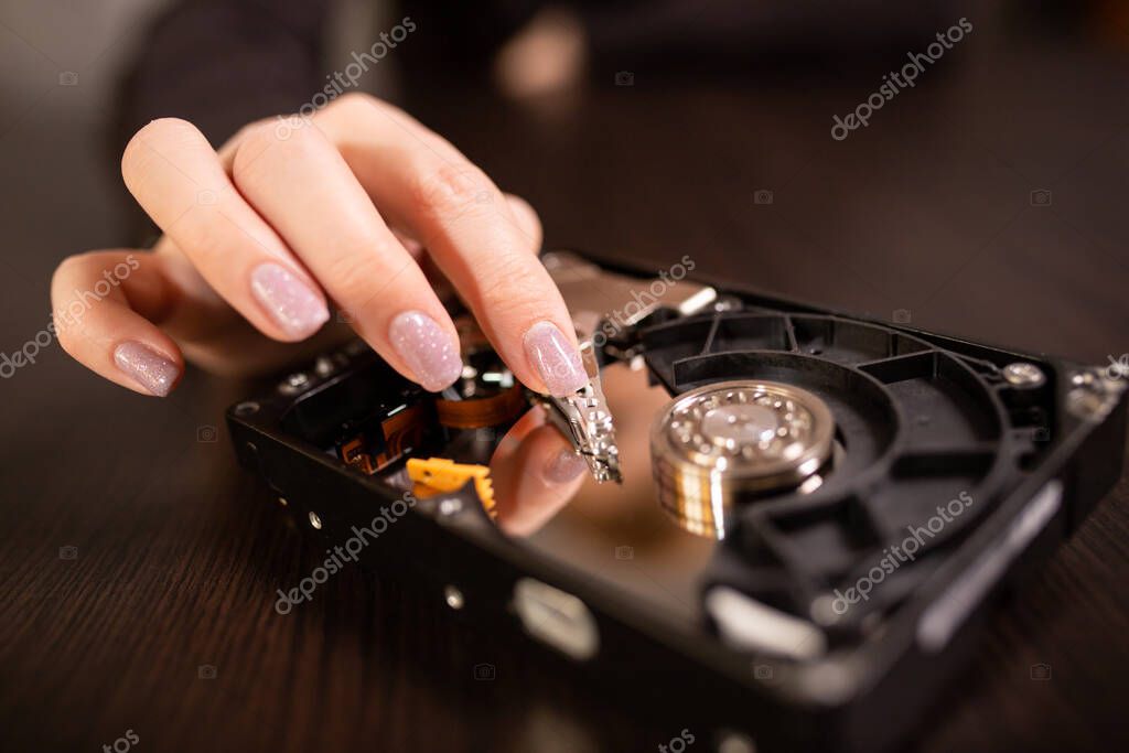 The girl touches the surface of the hard disk with her finger 2024