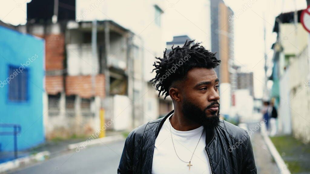 Un joven contemplativo negro caminando por la calle sintiéndose ...