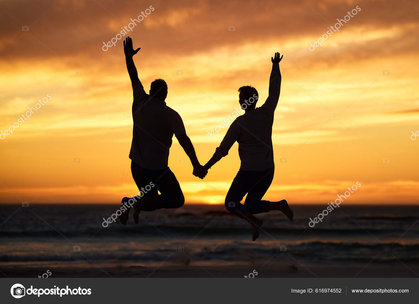 Two People Holding Hands In The Sunset