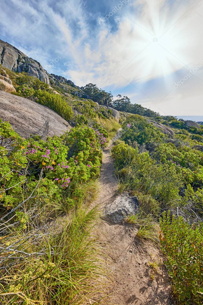 Un sendero de montaña con cielo azul nublado y lensflare. Paisaje de ...