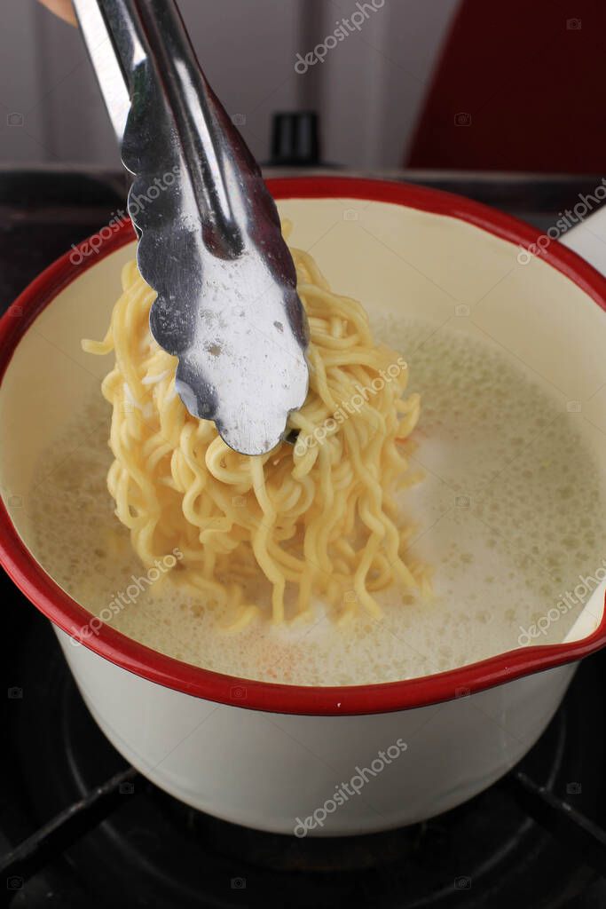 Fideos instantáneos hirviendo en la sartén de salsa, Mezcle fideos en ...