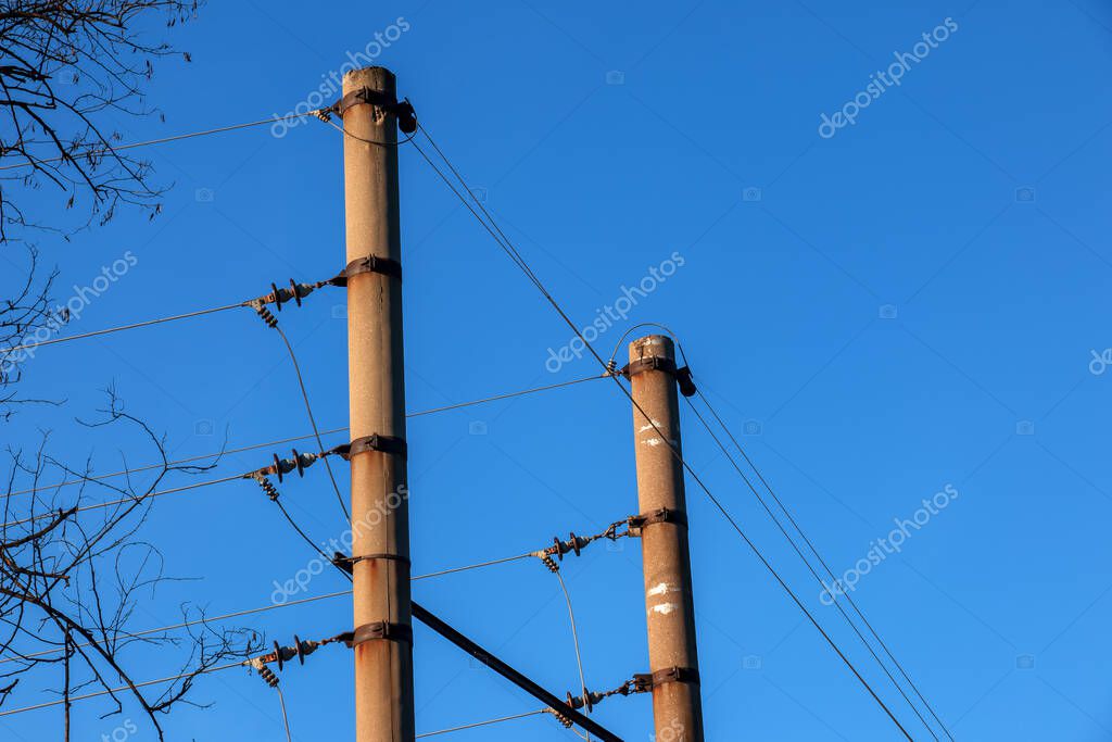 Poste eléctrico con un alambre lineal contra el cielo azul de cerca ...