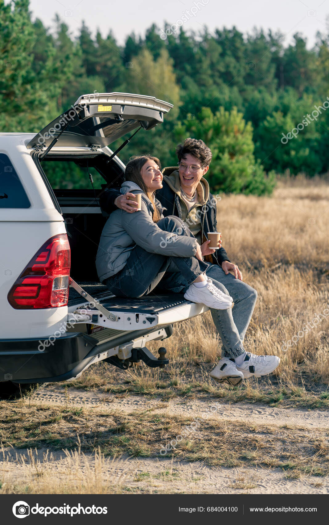 Guy Girl Sitting Together Open Trunk Crossover Talking Squinting Sun ...