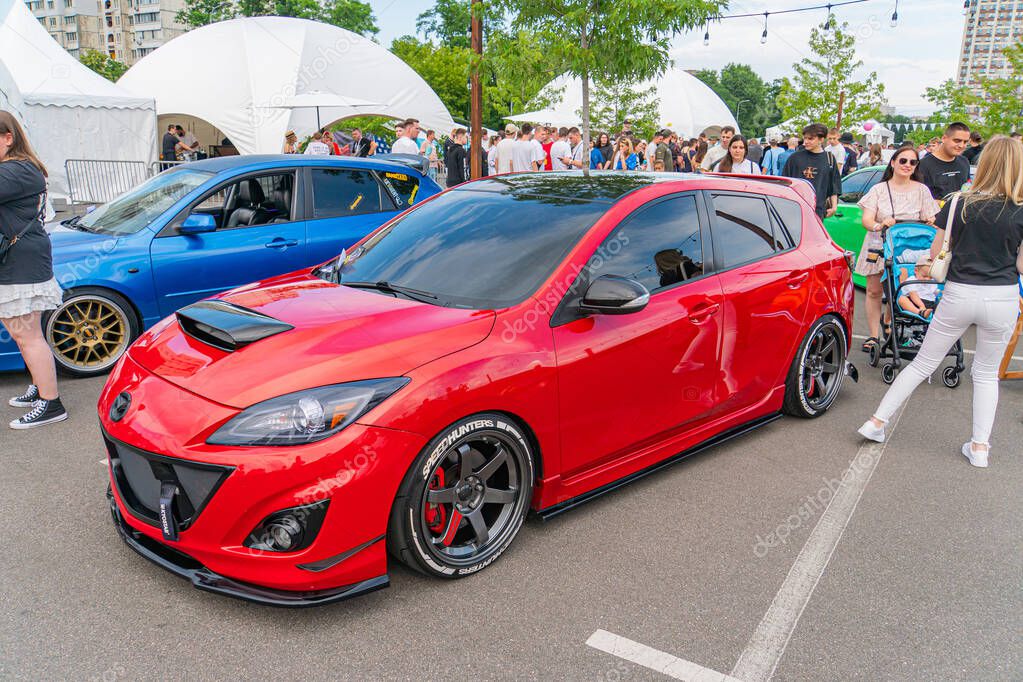 Un coche deportivo modificado rojo está estacionado en una zona de ...