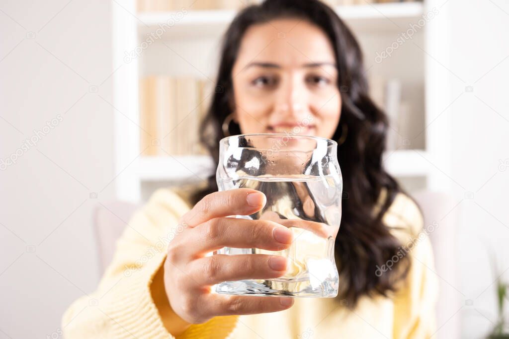 Un vaso de agua, una joven sonriente sosteniendo un vaso de agua ...