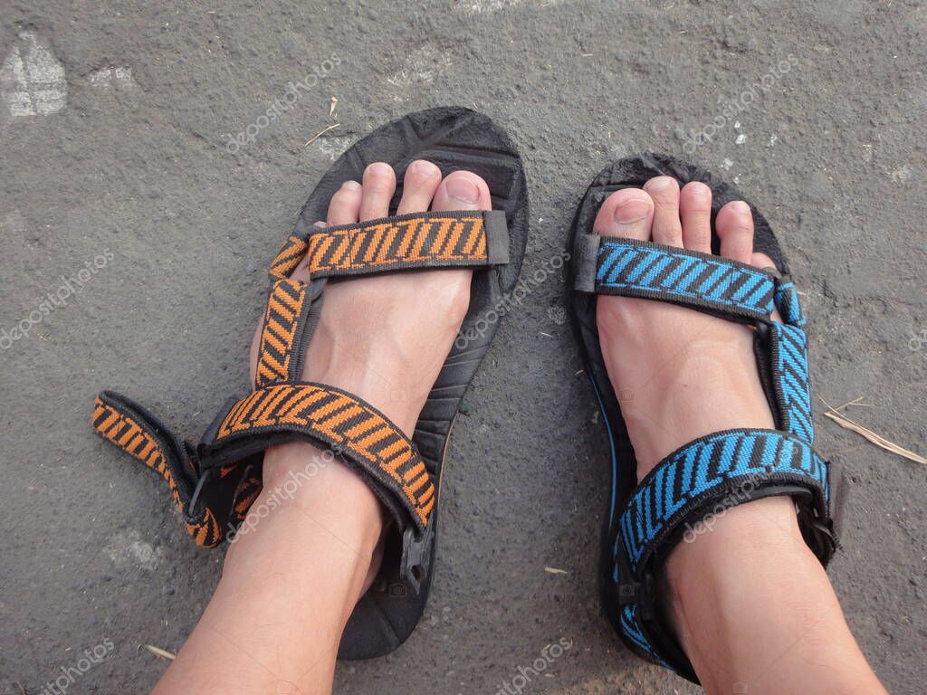 Los pies que usan sandalias son de diferentes colores, el izquierdo es ...