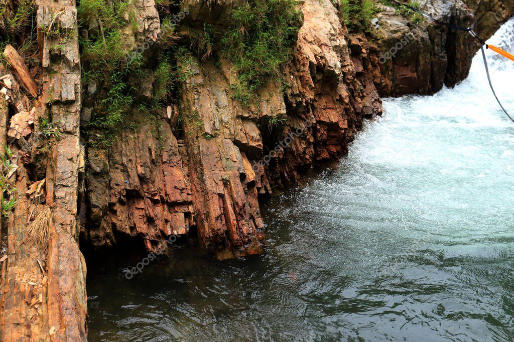 Una gran roca sedimentaria en capas se asienta en el río Boro-Boro ...