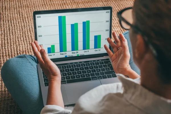 Close up rear view young woman using laptop and calculator, working on ...