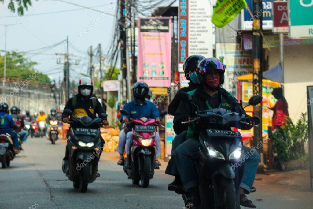 Jakarta, Indonesia in November 2022. Front view of a motorcyclist driving on a busy street on ...
