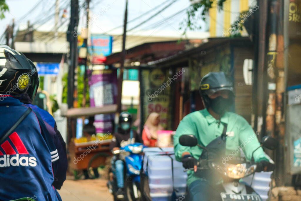 Jakarta, Indonesia in November 2022. Front view of a motorcyclist driving on a busy street on ...