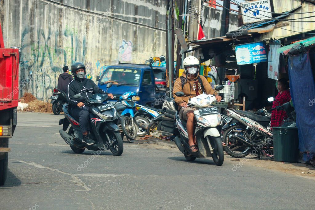 Jakarta, Indonesia in November 2022. Front view of a motorcyclist driving on a busy street on ...