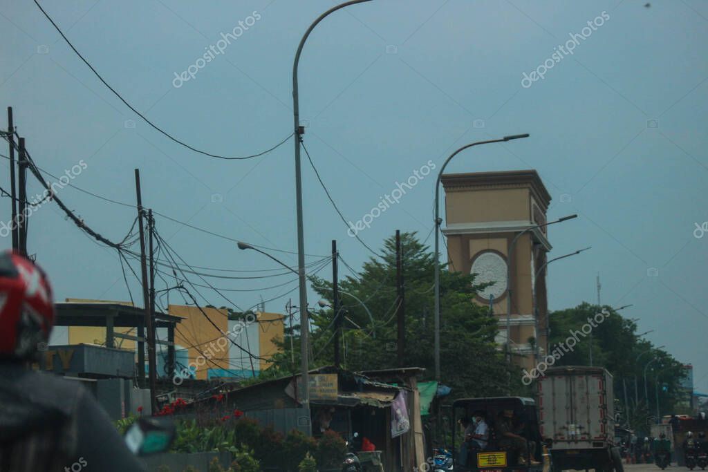 Jakarta, Indonesia in November 2022. Back view of a motorcyclist driving on a busy street on the ...