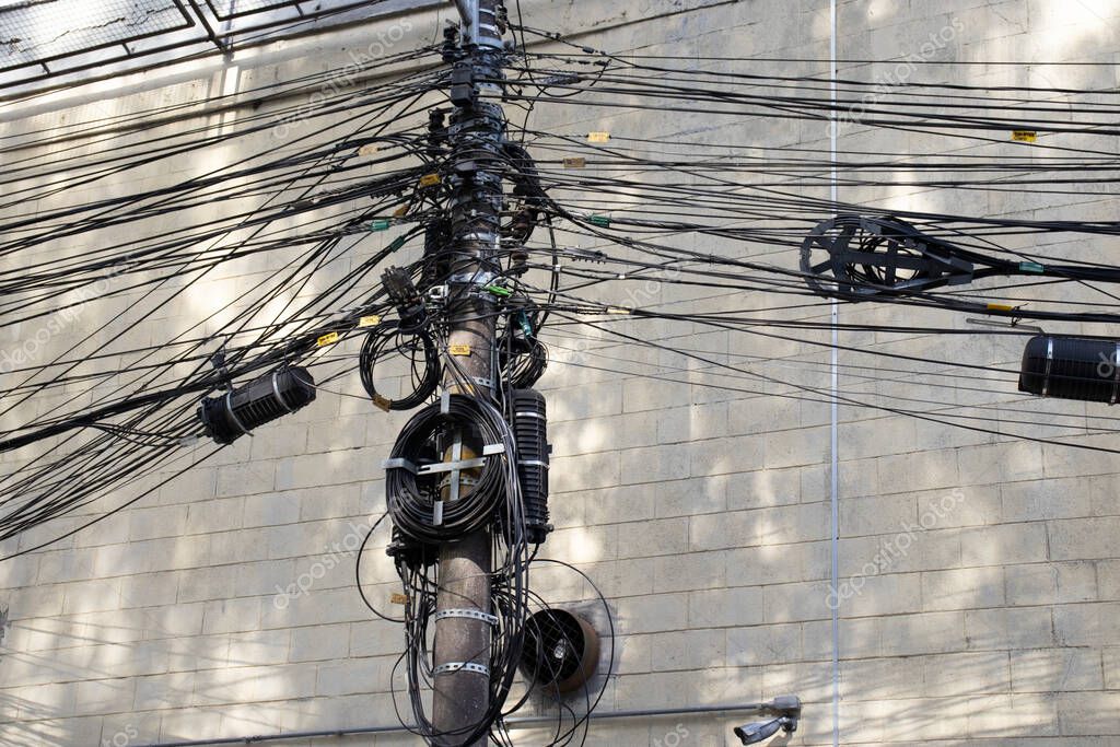 Muchos cables conectados al poste eléctrico, el caos de cables y cables ...