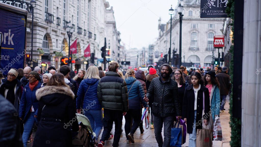 Misa de personas caminando por las calles de Londres en cámara lenta ...