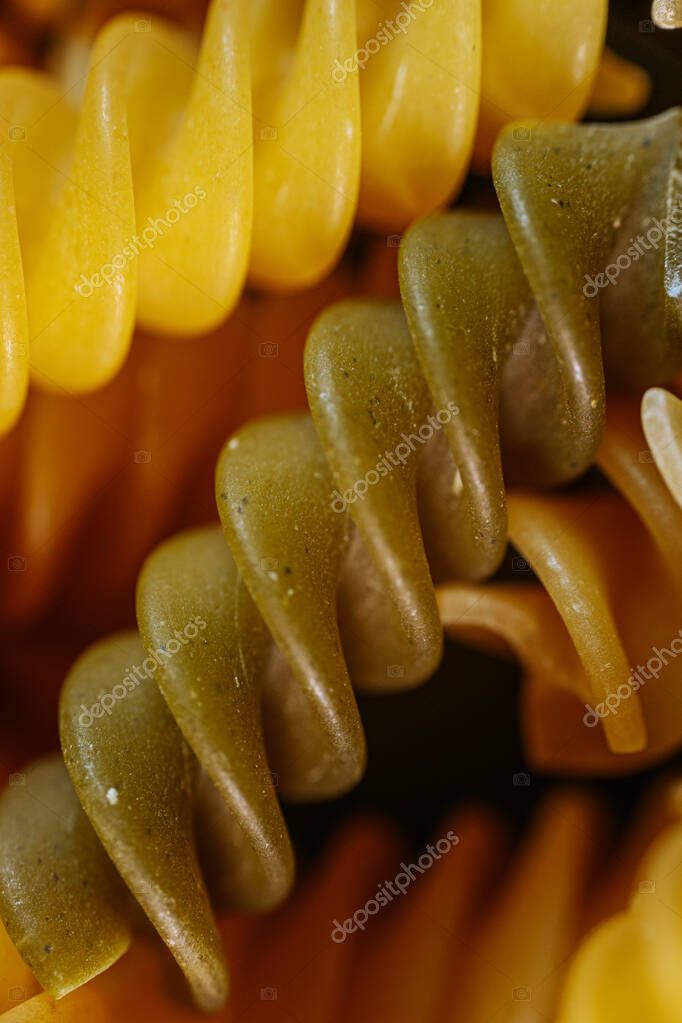 Un colorido primer plano de pasta espiral seca en tonos anaranjados ...