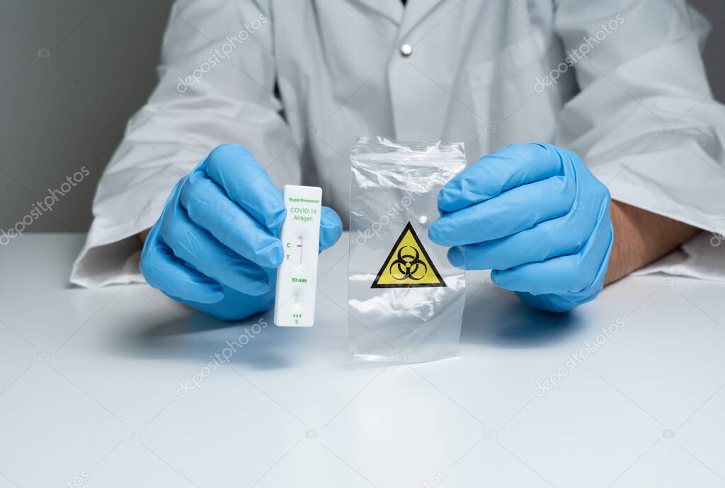 Nurse display of negative Covid-19 antigen rapid test near biohazard ...