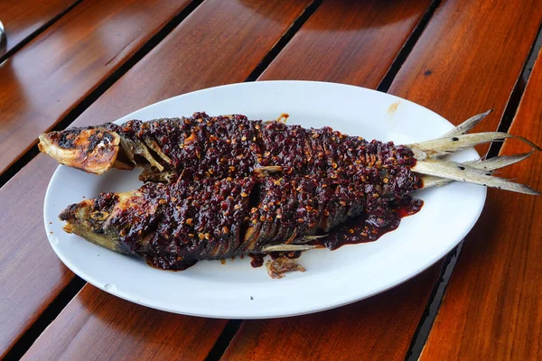 Fried milk fish covered with spicy chilisauce and shrimp paste served ...