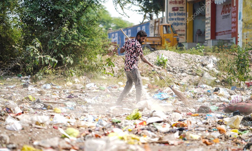 Diciembre, 2022, Raipur, India: Hombre barriendo la basura con escoba y ...