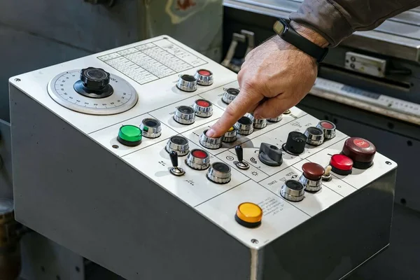 The worker controls the control panel for switching modes of grinding ...