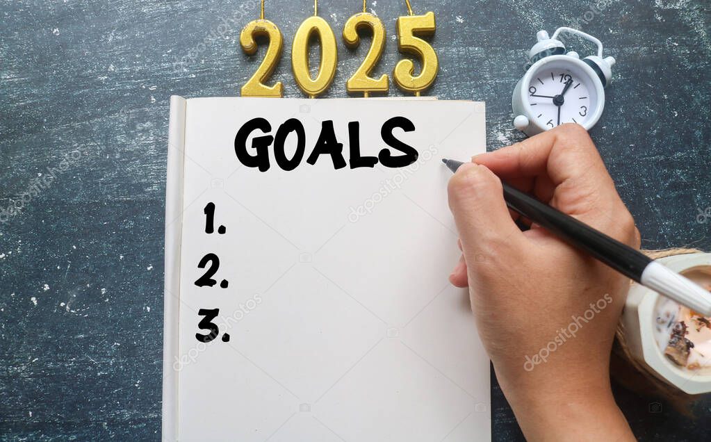 Una persona escribe 2025 Metas en un cuaderno rodeado de velas de ...