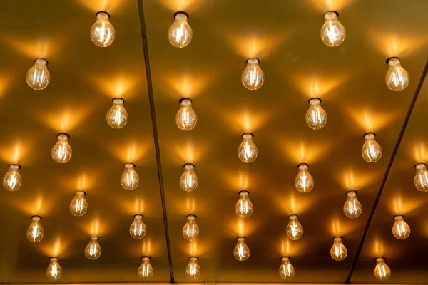 Luminous light bulbs in a row on the ceiling. Theatre light bulbs ...