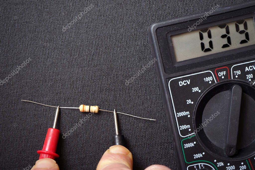 Measuring the value of an electrical resistor with an ohmmeter. 2024