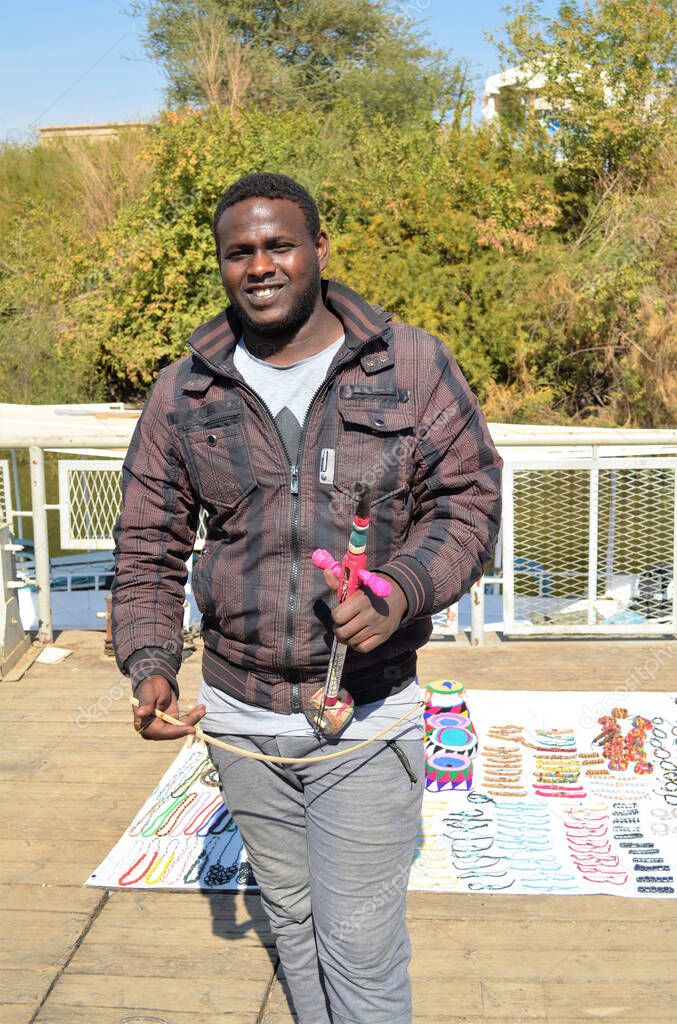 Asuán, Egipto - 14 de enero de 2016: Un vendedor de recuerdos rababa ...