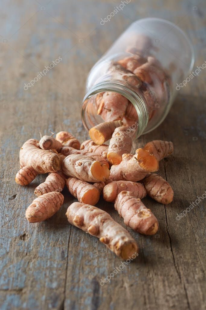 rizomas o raíces de cúrcuma limpios dispersos en la mesa con una ...