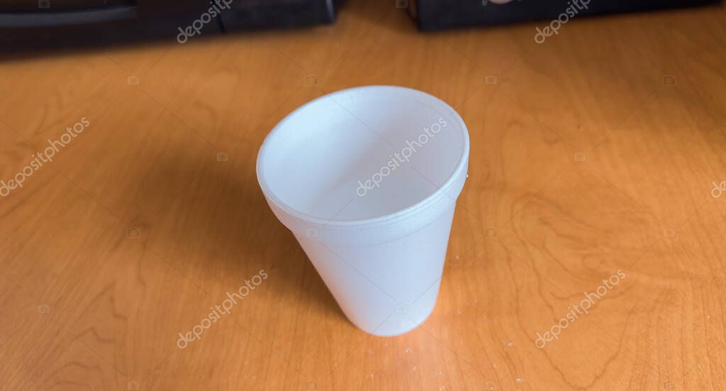 taza de espuma de poliestireno en la mesa simboliza la conveniencia y ...