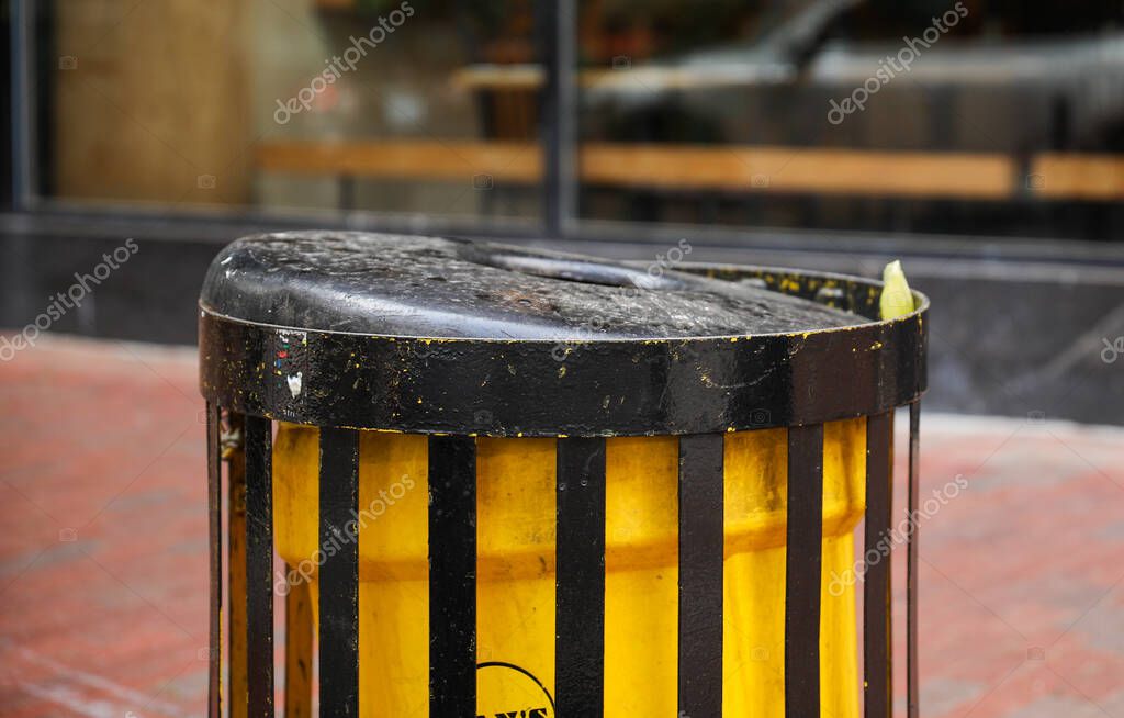 Un cubo de basura desechado se sienta en una calle estéril ...