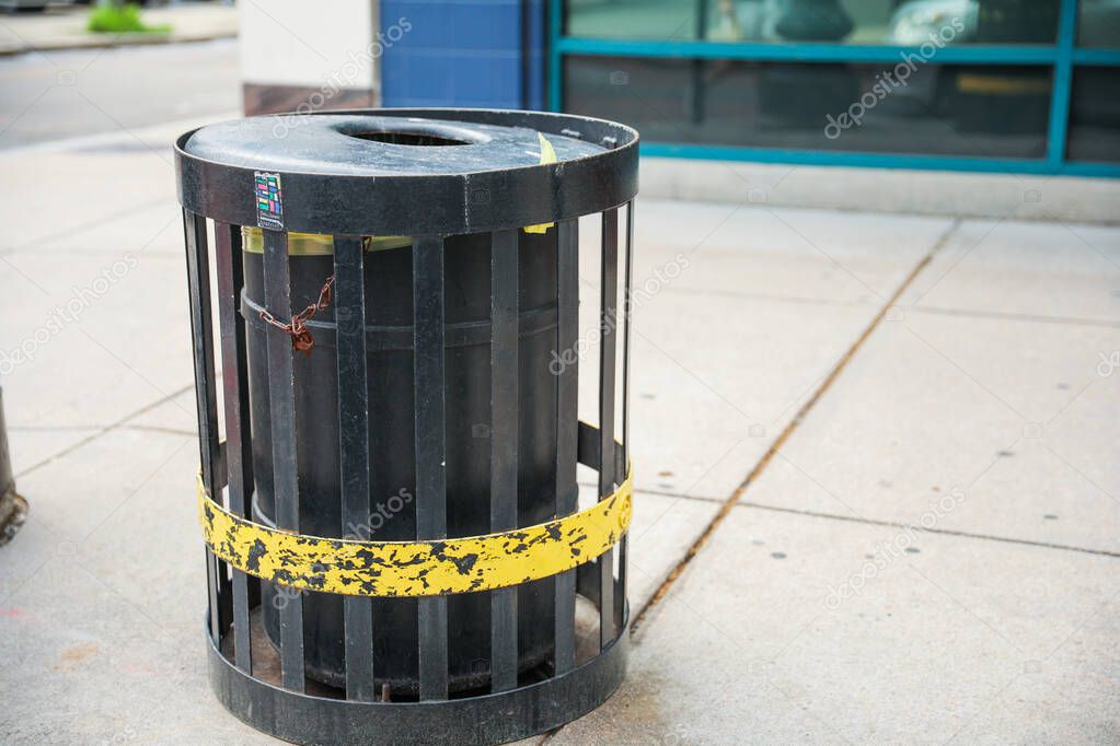 Un cubo de basura desechado se sienta en una calle estéril ...