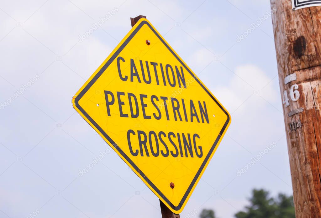 letrero peatonal amarillo se encuentra alto en una calle concurrida ...