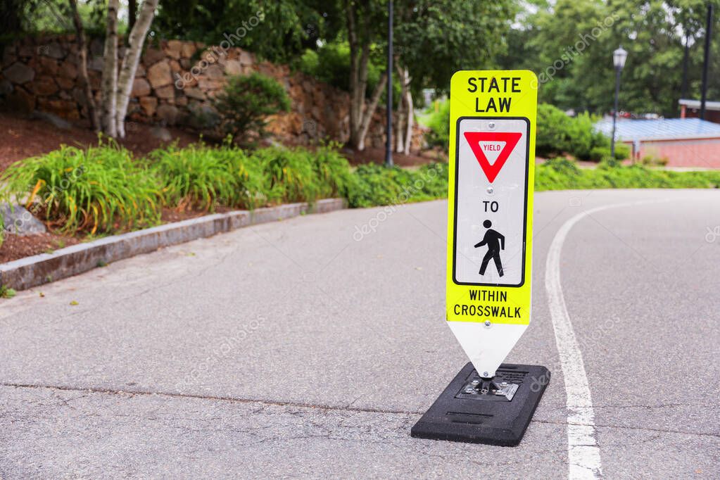 letrero peatonal amarillo se encuentra alto en una calle concurrida ...