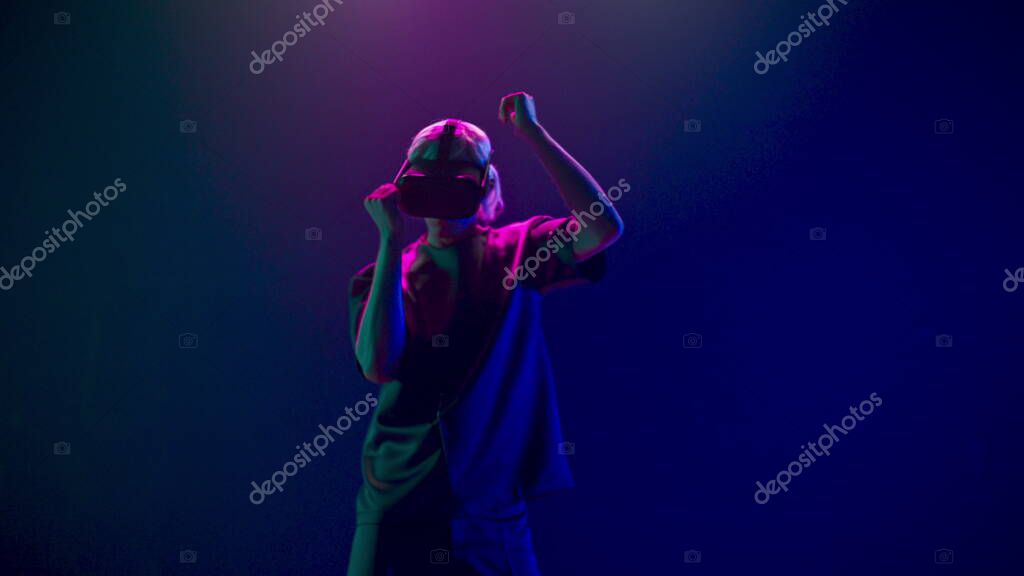 Addicted man gaming moving in invisible space using VR. Young blonde ...