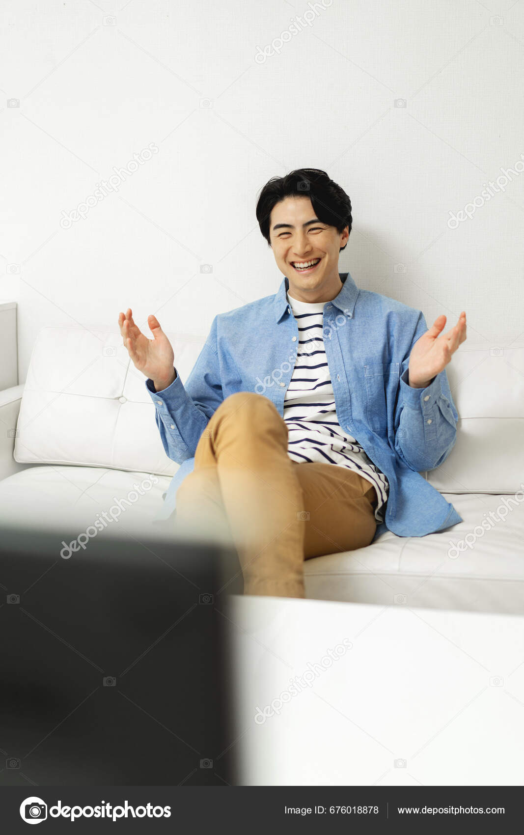 Happy Asian Young Man Watching Home — Stock Photo © Paylessimages ...