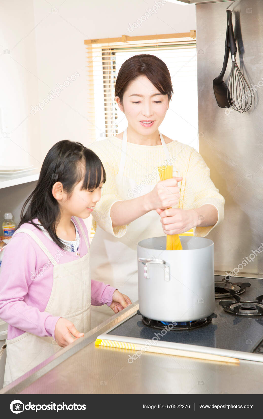 Mother Daughter Cooking Spaghetti — Stock Photo © Paylessimages #676522276