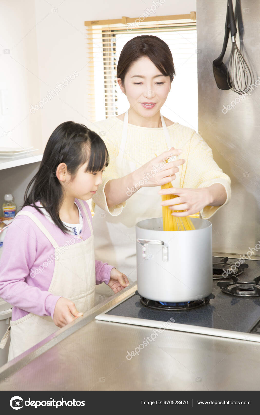Mother Daughter Cooking Spaghetti — Stock Photo © Paylessimages #676528476