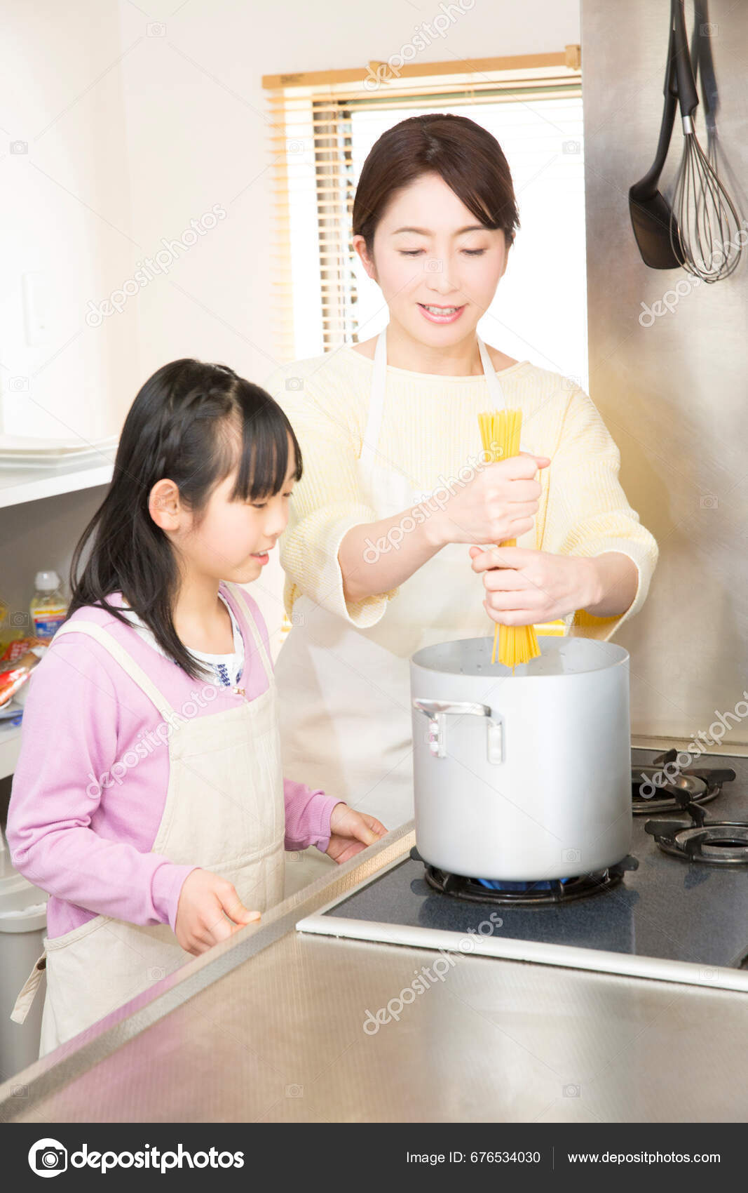 Mother Daughter Cooking Spaghetti — Stock Photo © Paylessimages #676534030