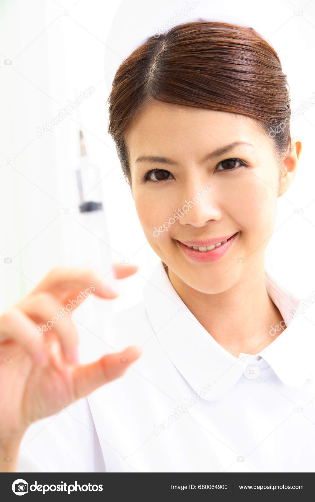 Beautiful Japanese Nurse Holding Syringe — Stock Photo © Paylessimages #680064900