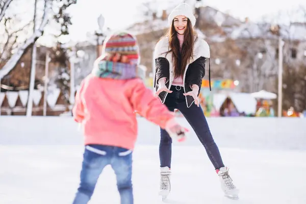 Mother with daughter teaching ice skating on a rink - Stock Image ...
