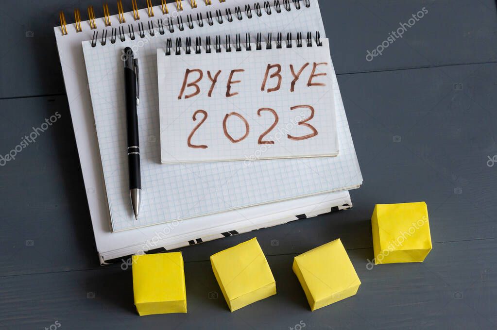 adiós 2023 en un bloc de notas, en blanco post-its. cubos amarillos ...