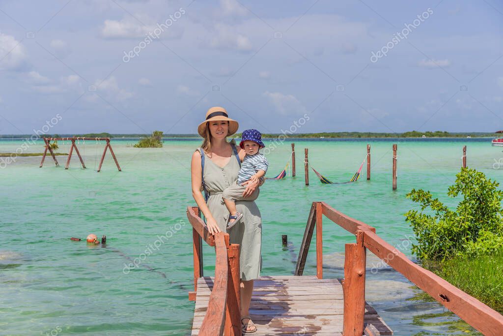 Madre con su hijo pequeño explorando el muelle de madera sobre las ...