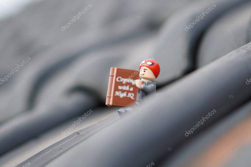 Minifigura de Lego Peter Parker sentado leyendo un libro en el techo 2024
