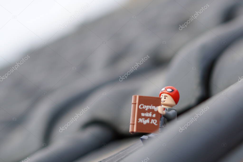 Minifigura de Lego Peter Parker sentado leyendo un libro en el techo 2024