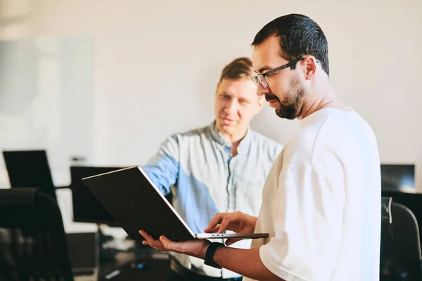 Portrait of two professional male programmers working on computer in ...