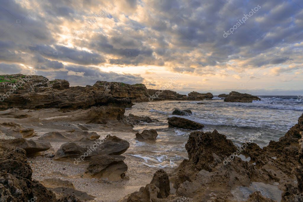 Una cala rocosa y una playa de arena bajo un cielo expresivo al ...
